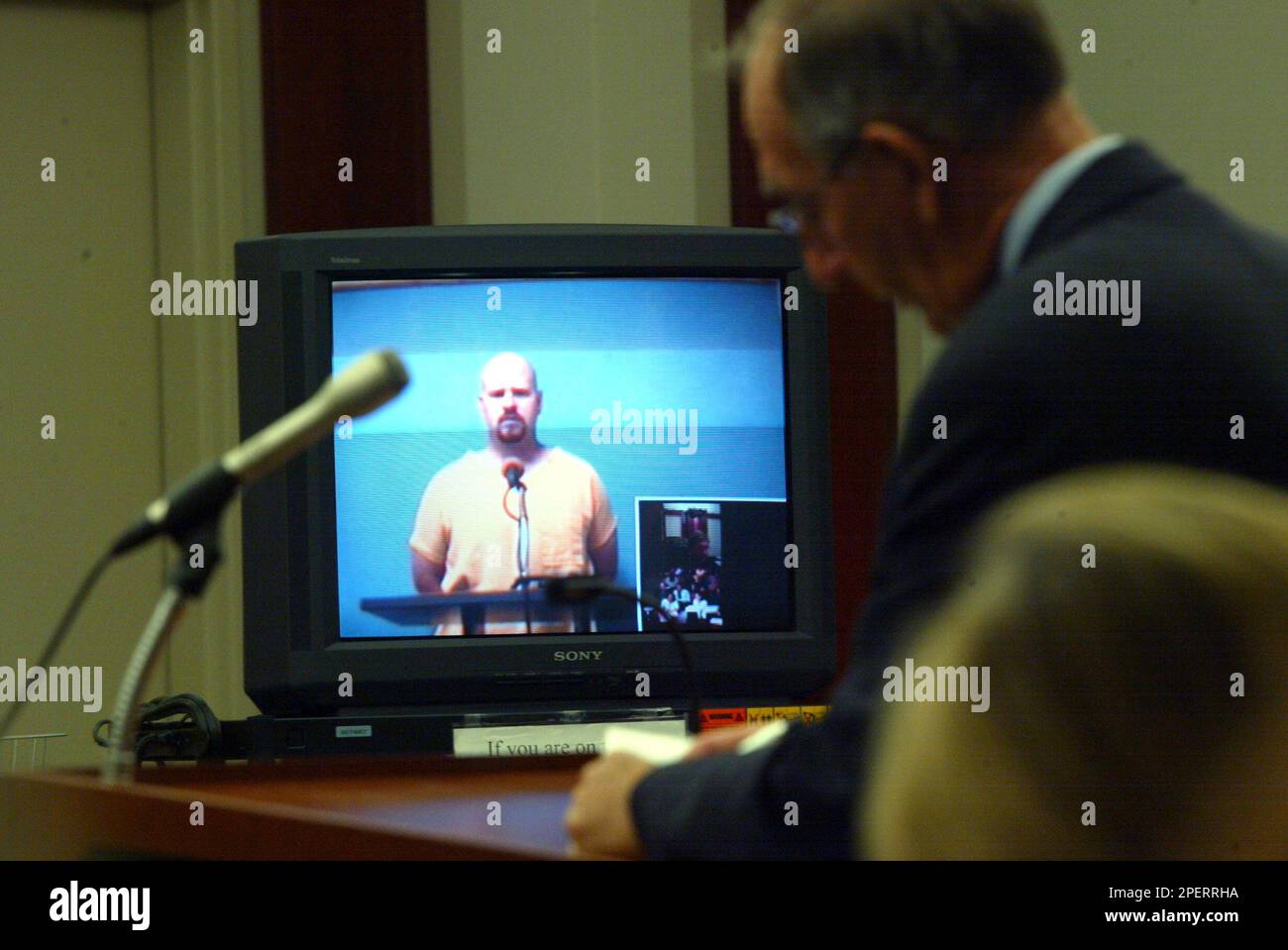 Mark Hacking, on monitor at left, appears in court during his initial ...