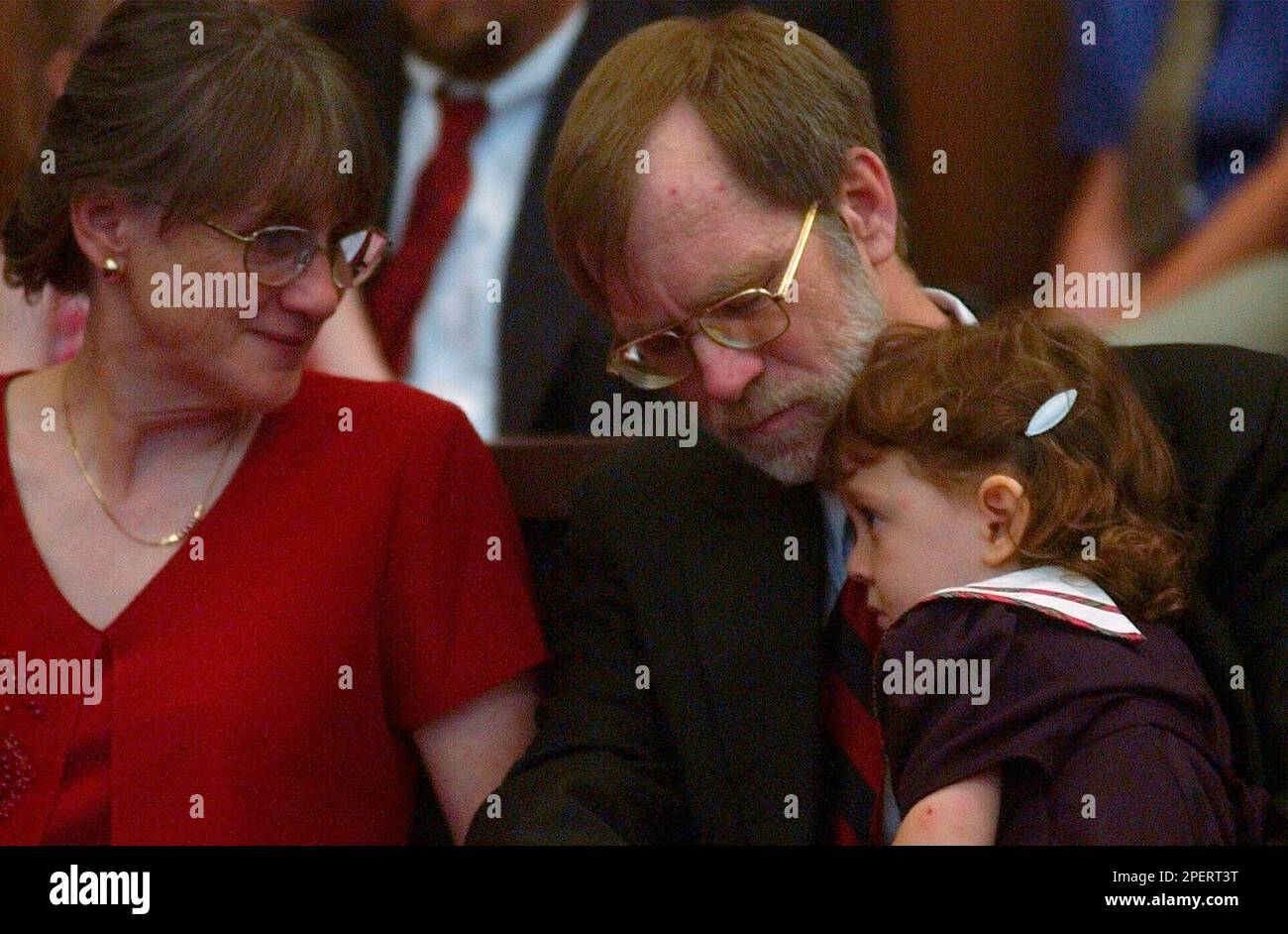 Leon Holmes, right, holds one of his grandchildren, Bernadette Holmes, 4, as his wife Susan ...
