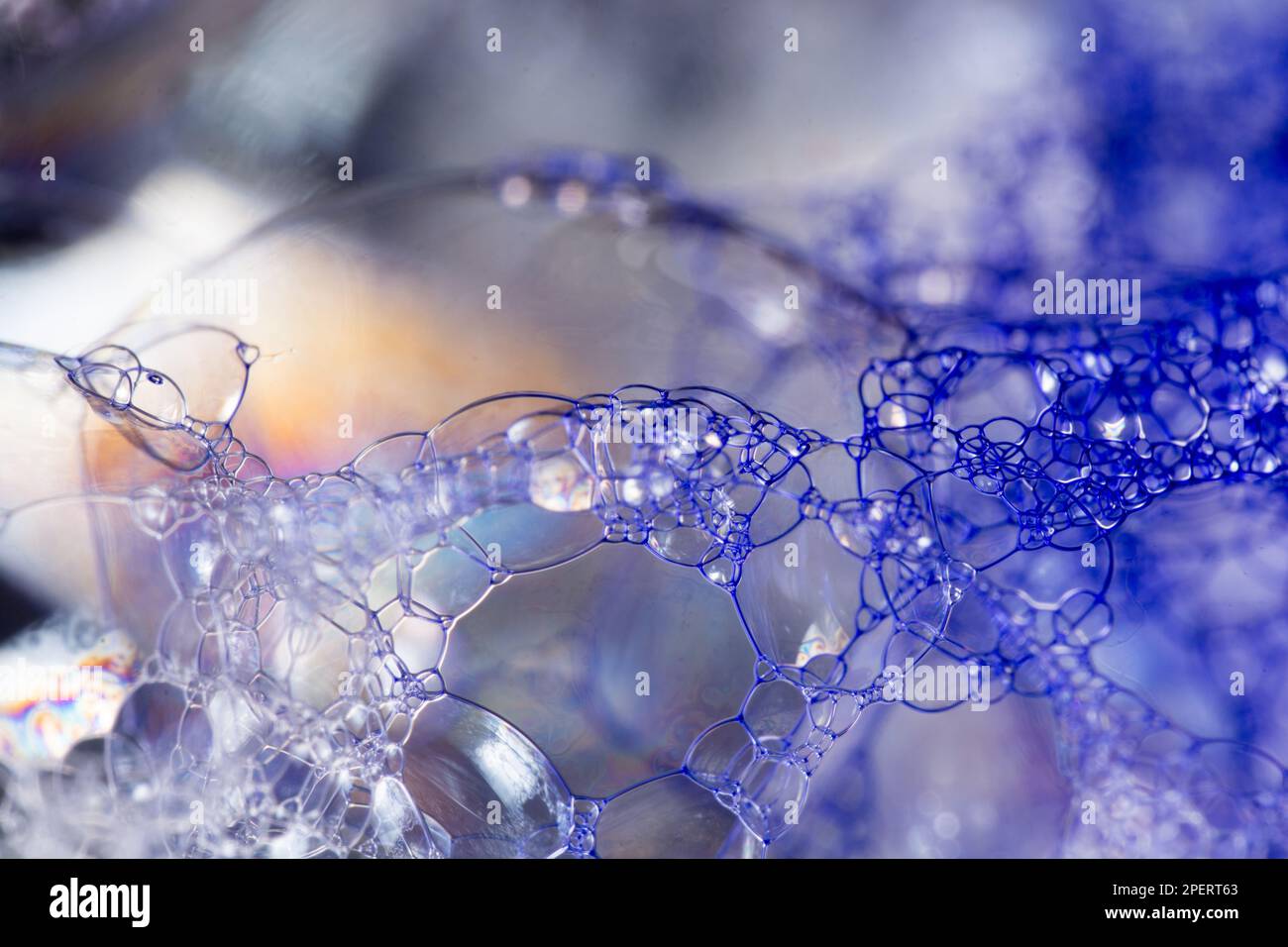 A closeup of blue translucent soap bubbles floating on the water ...