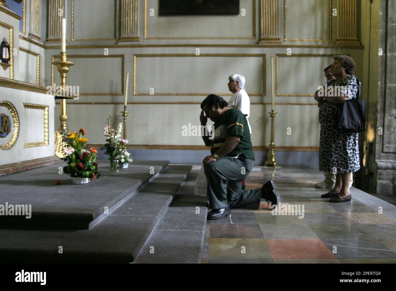 People pray at the altar of the "Captive Child" inside of the National ...