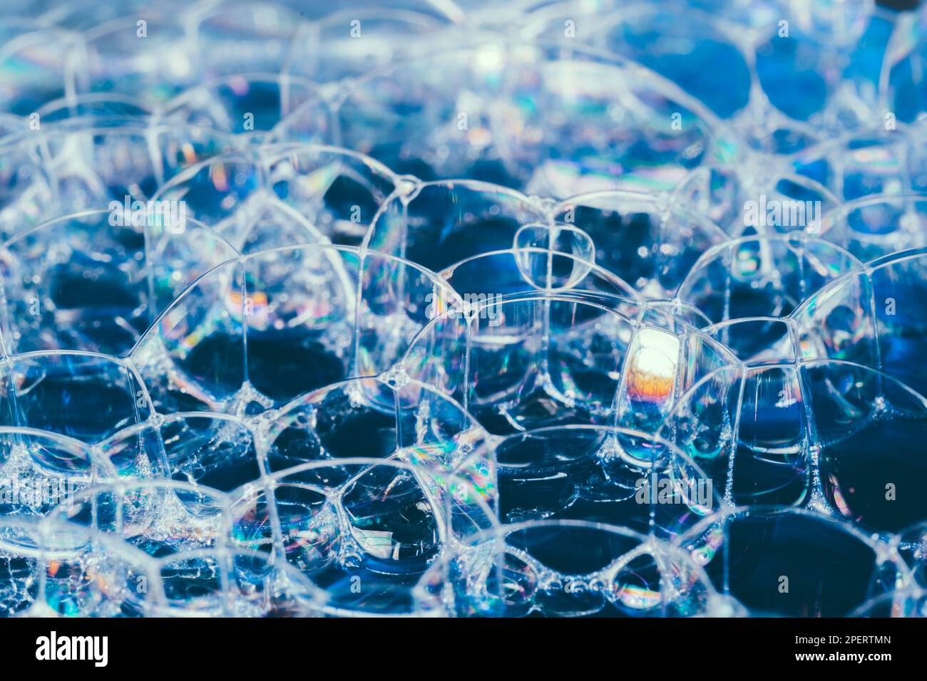 A closeup of blue translucent soap bubbles floating on the water ...