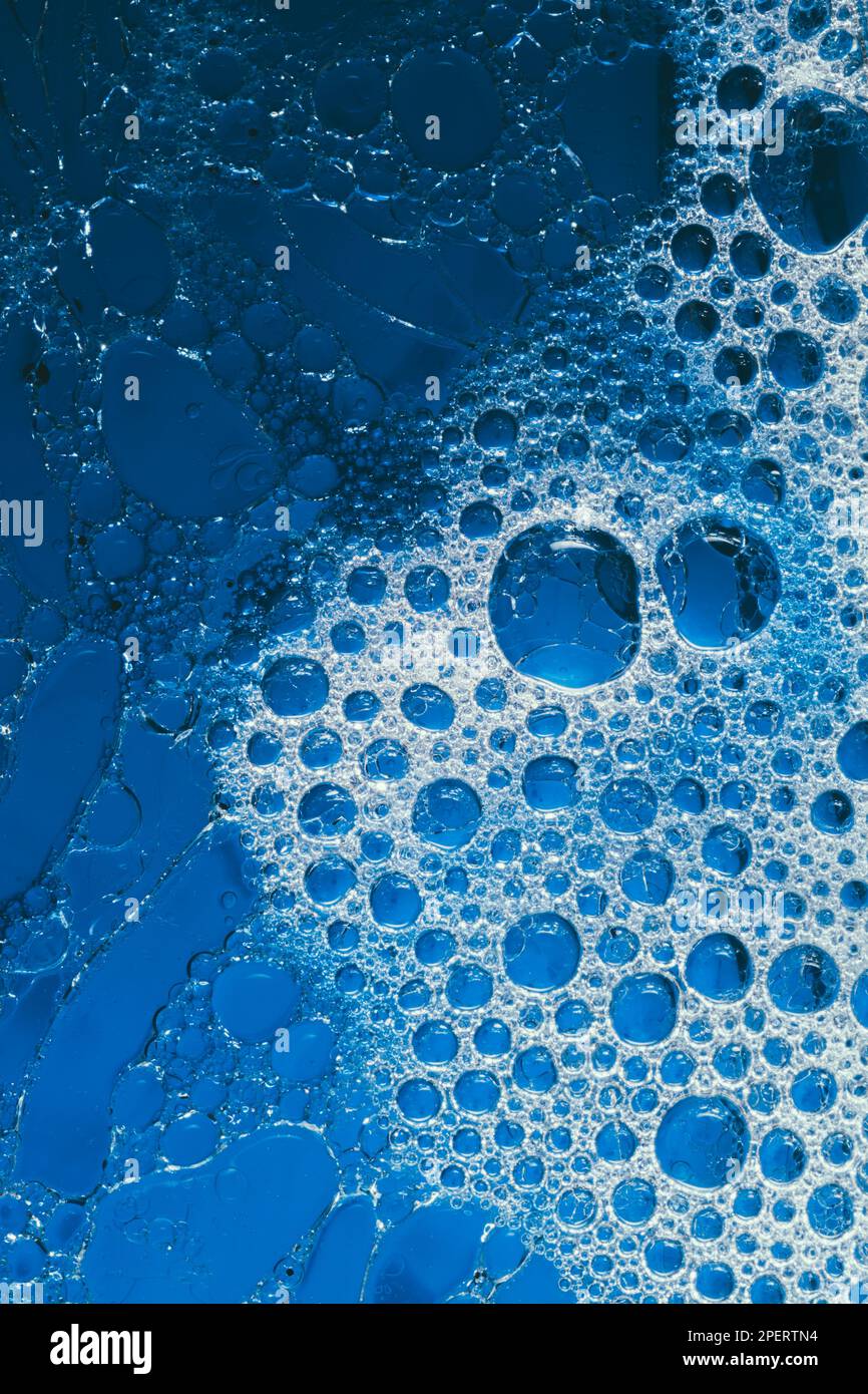 A closeup of blue translucent soap bubbles floating on the water ...