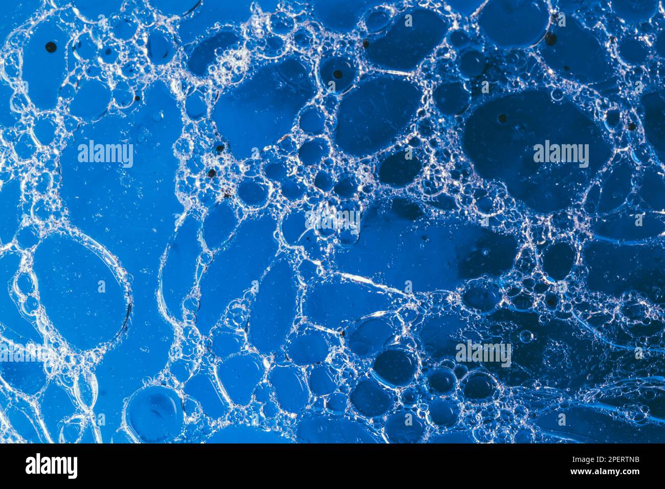 A closeup of blue translucent soap bubbles floating on the water ...