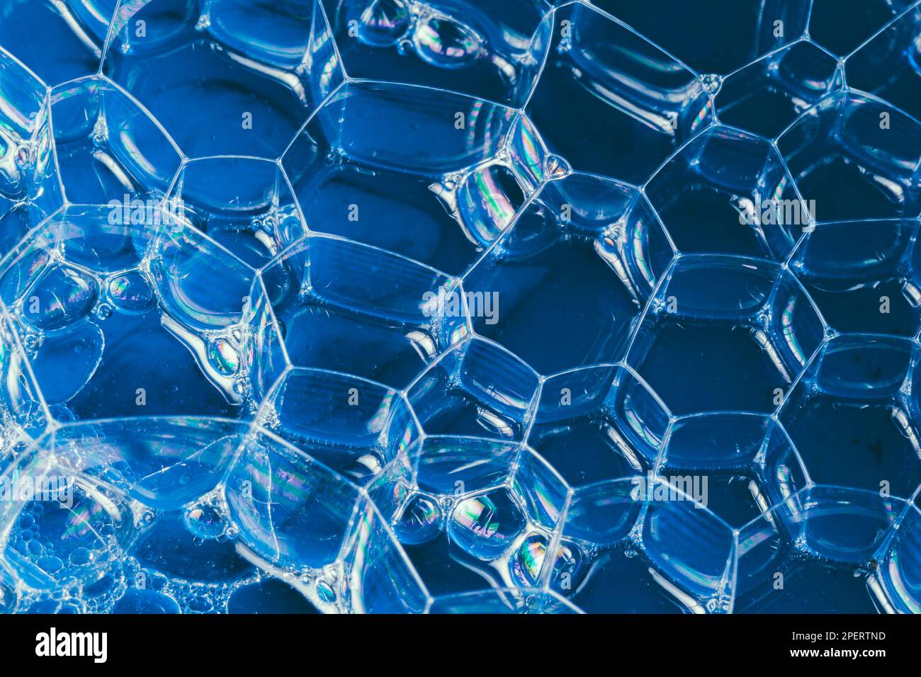 A closeup of blue translucent soap bubbles floating on the water ...