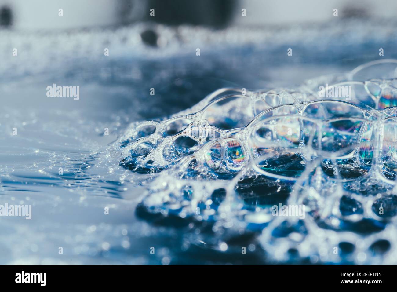 A closeup of blue translucent soap bubbles floating on the water ...