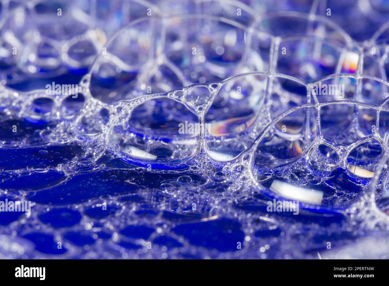 A closeup of blue translucent soap bubbles floating on the water ...