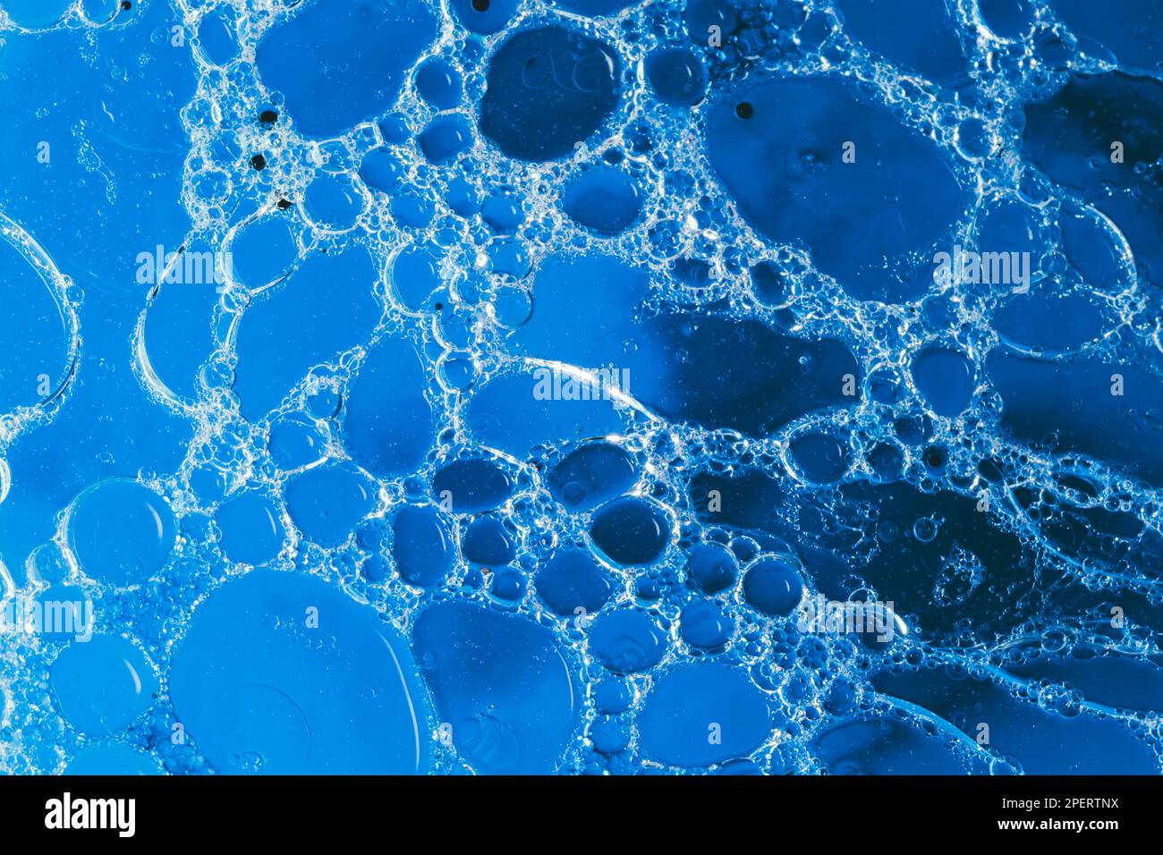 A closeup of blue translucent soap bubbles floating on the water ...