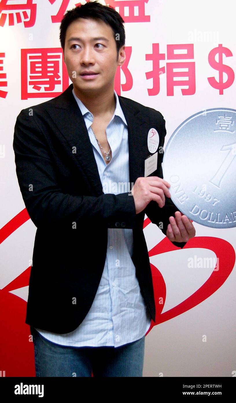 Hong Kong singer and actor Leon Lai holds a dummy Hong Kong dollar at ...