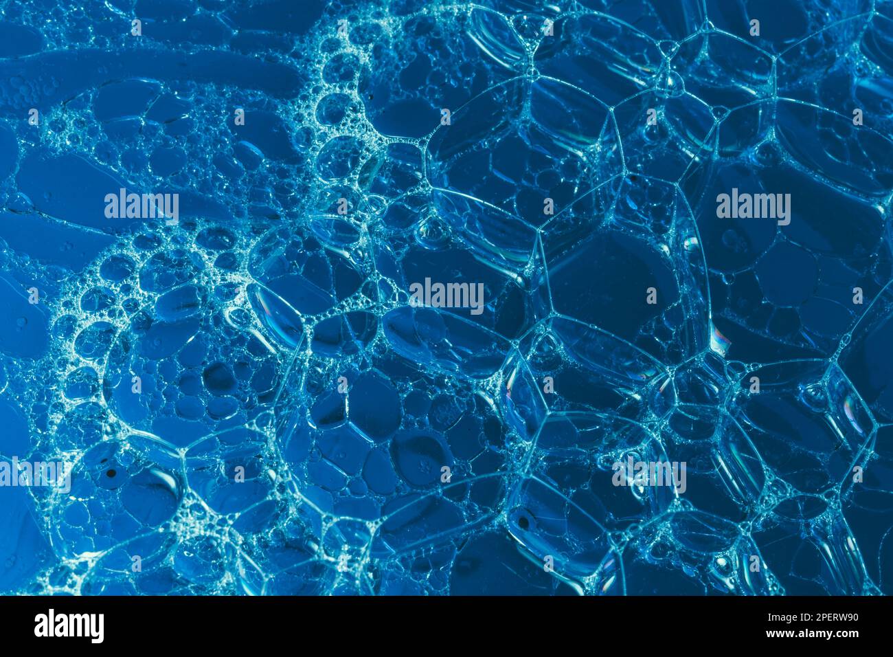 A closeup of blue translucent soap bubbles floating on the water ...