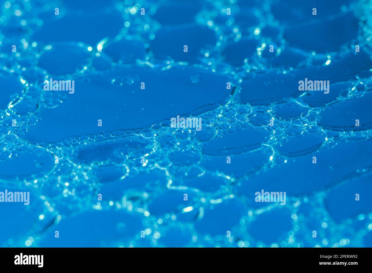 A closeup of blue translucent soap bubbles floating on the water ...