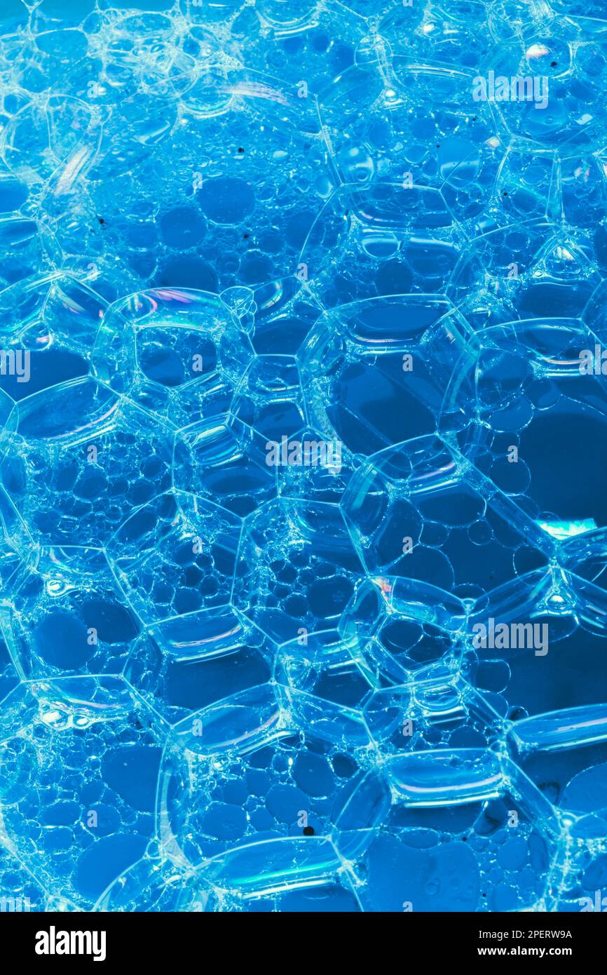 A closeup of blue translucent soap bubbles floating on the water ...
