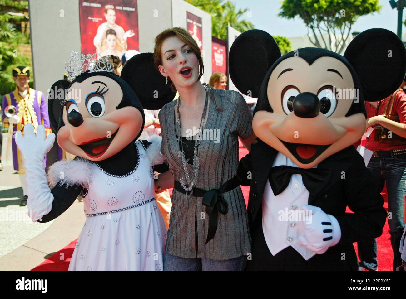 Actress Anne Hathaway poses with Mickey Mouse, right and Minnie Mouse ...