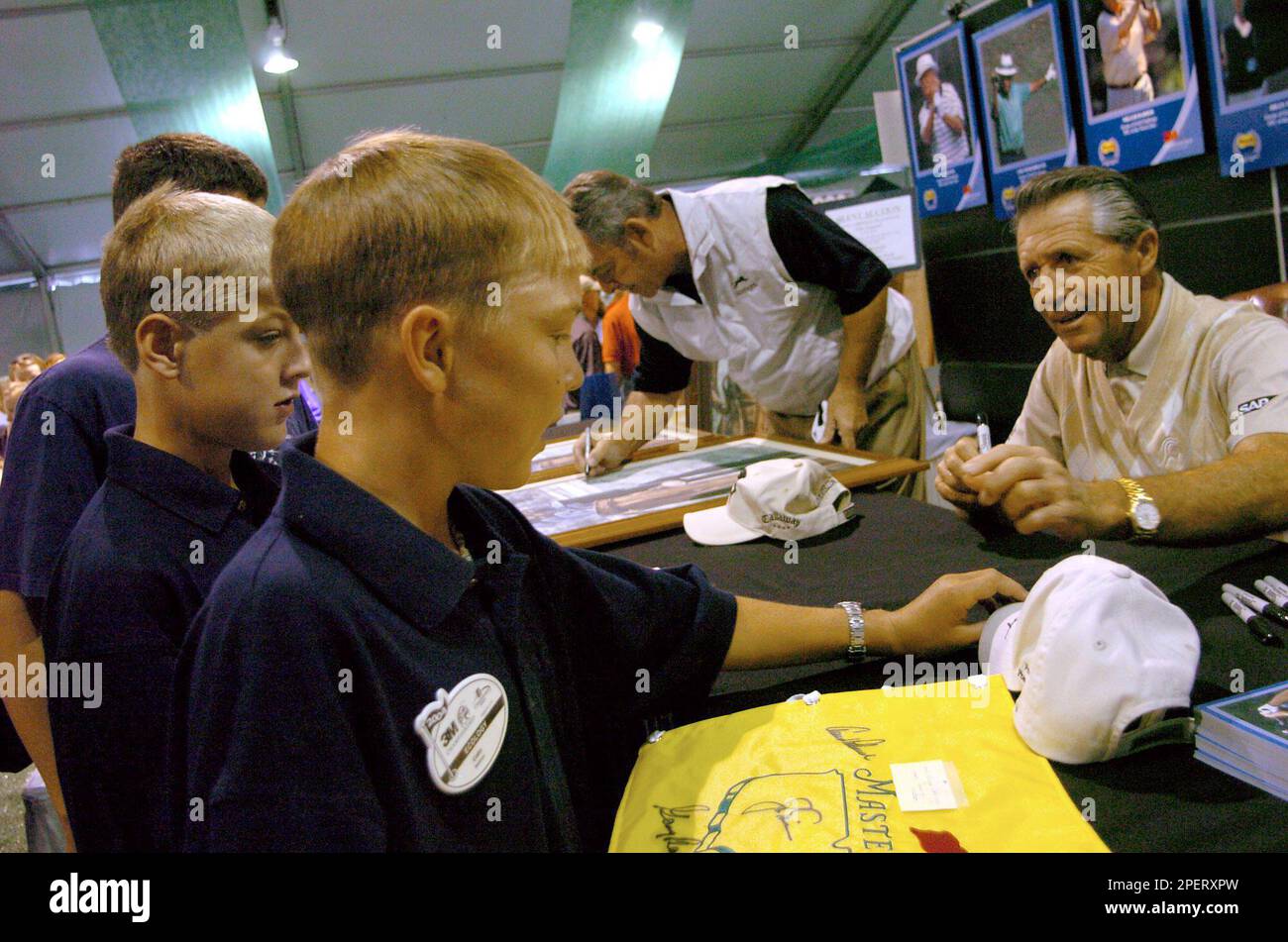 Colin Baartman, 13, of Andover, Minn., takes his hat from Gary Player ...