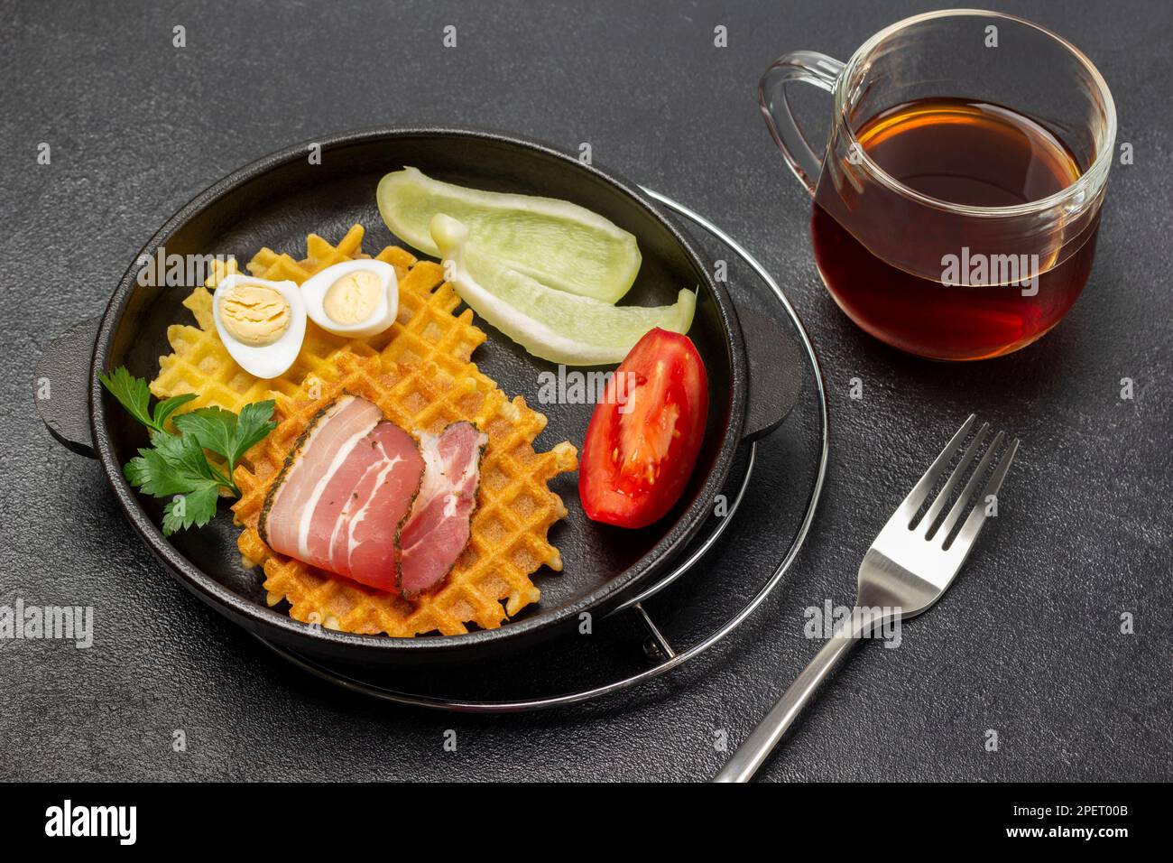 Fresh pepper and tomato wedge, waffles, fried bacon and eggs in a ...