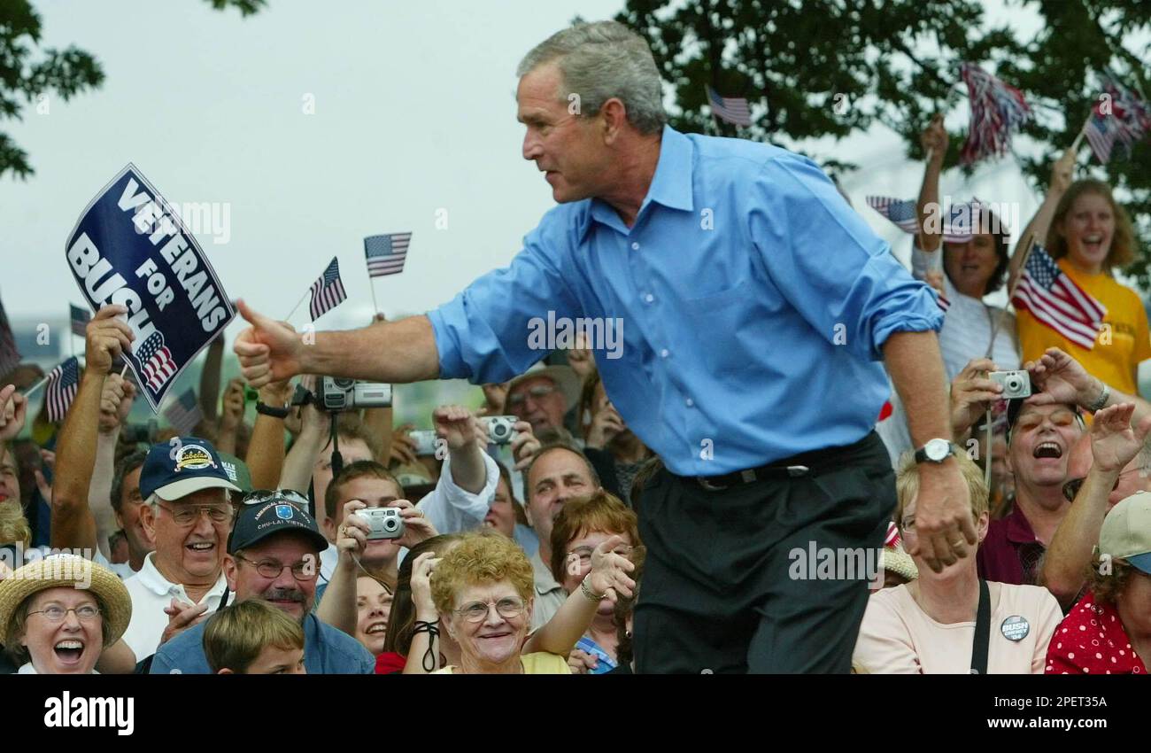 President Bush gives a 'thumbs-up' sign to supporters as he is ...