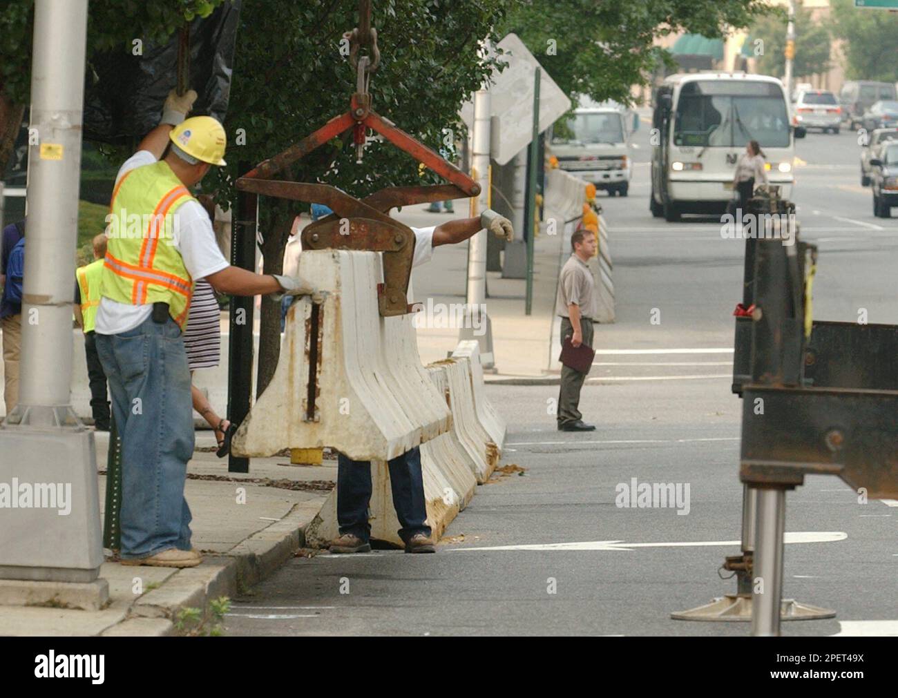 Workers place concrete Jersey barriers as a safety blockade around ...