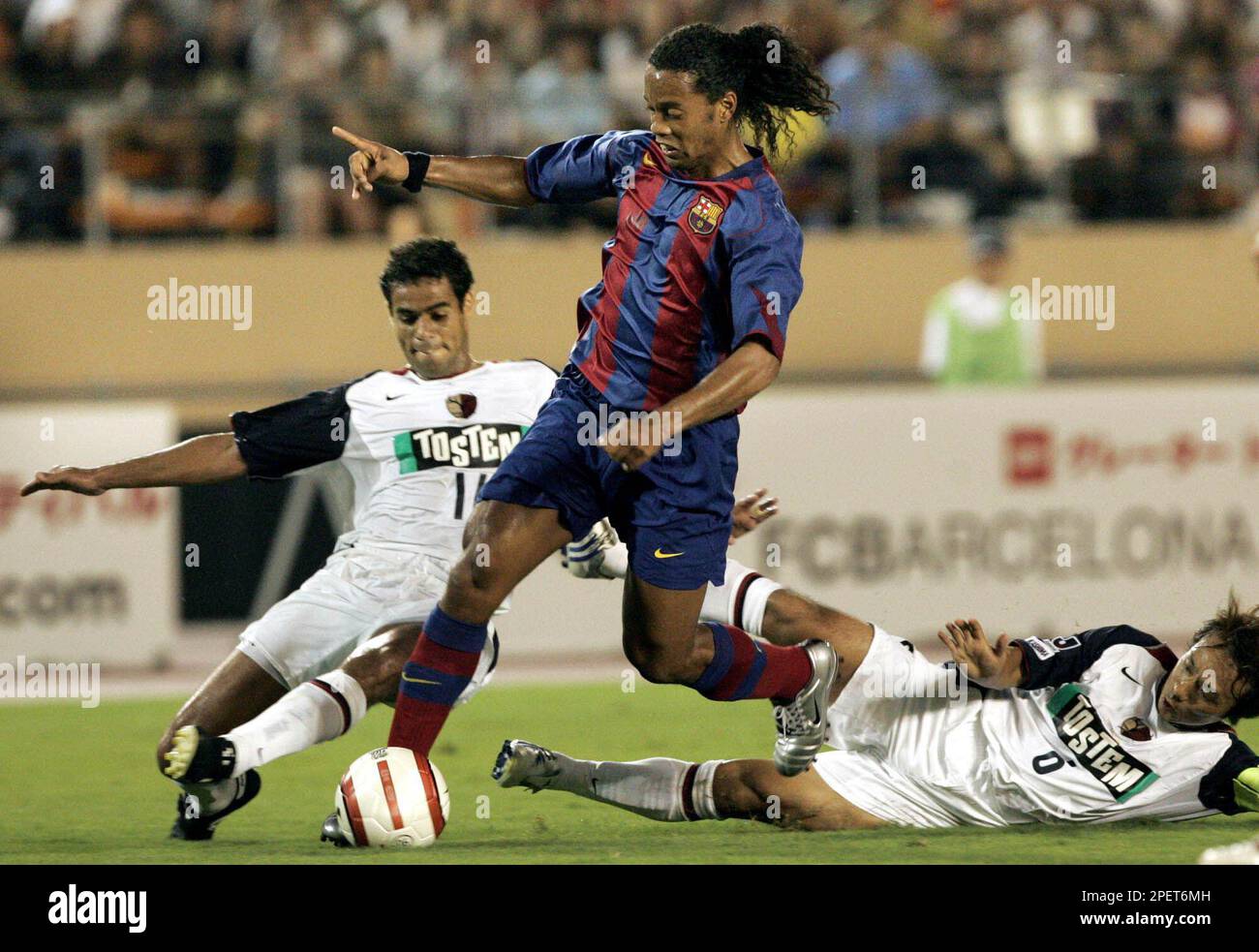 FC Barcelona midfielder Ronaldinho, center, sews his way between Japan ...
