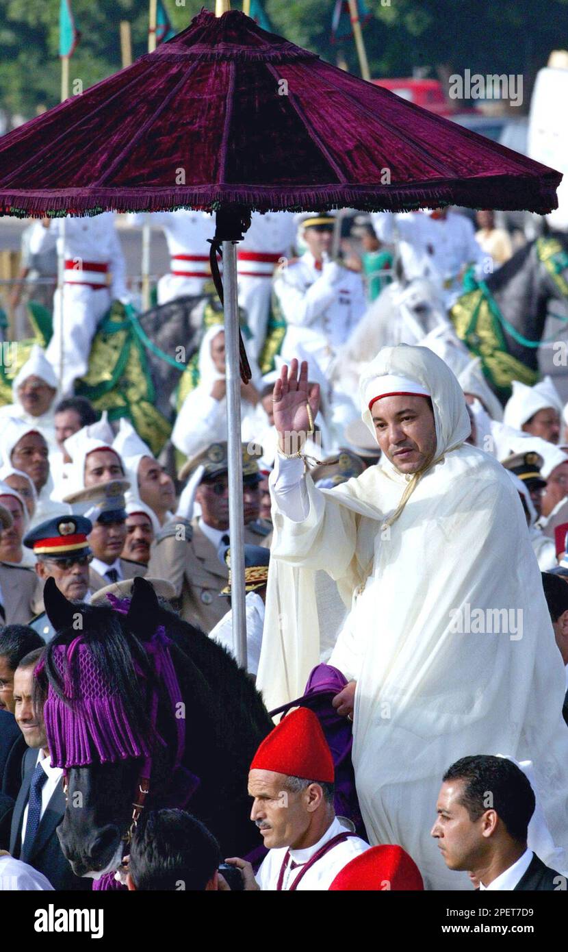 King Mohammed VI of Morocco, riding a horse, waves to wellwishers as he ...