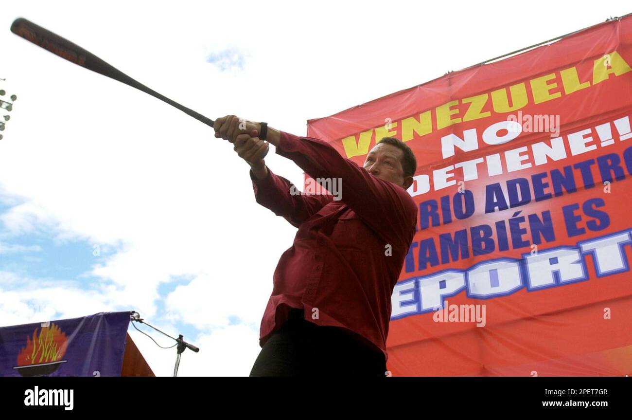 Venezuelan President Hugo Chavez swings a baseball bat at an event ...