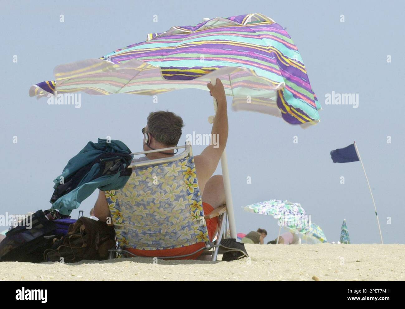 Joseph Kooklin of Fairhaven, N.J., holds onto his umbrella at the beach ...