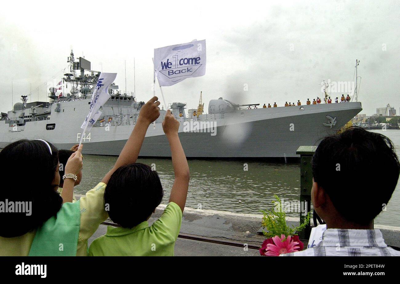 Family members and Children of Indian naval personnel wave flags to ...