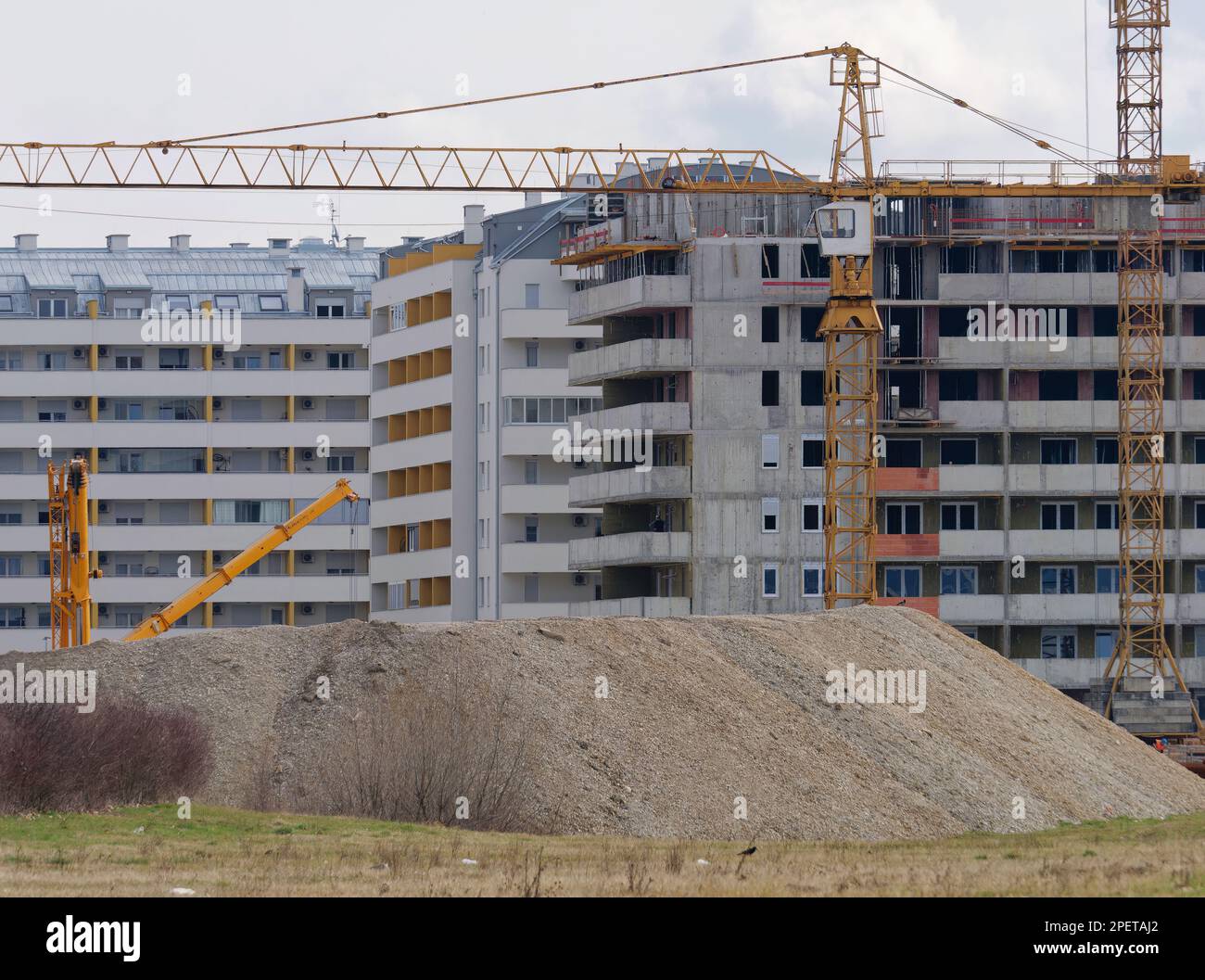 A construction site with tower cranes and half-built buildings Stock ...