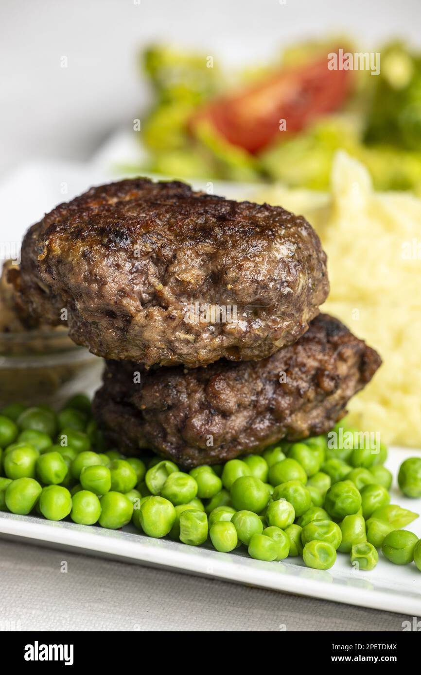 Bavarian Meat Patty With Peas Stock Photo - Alamy