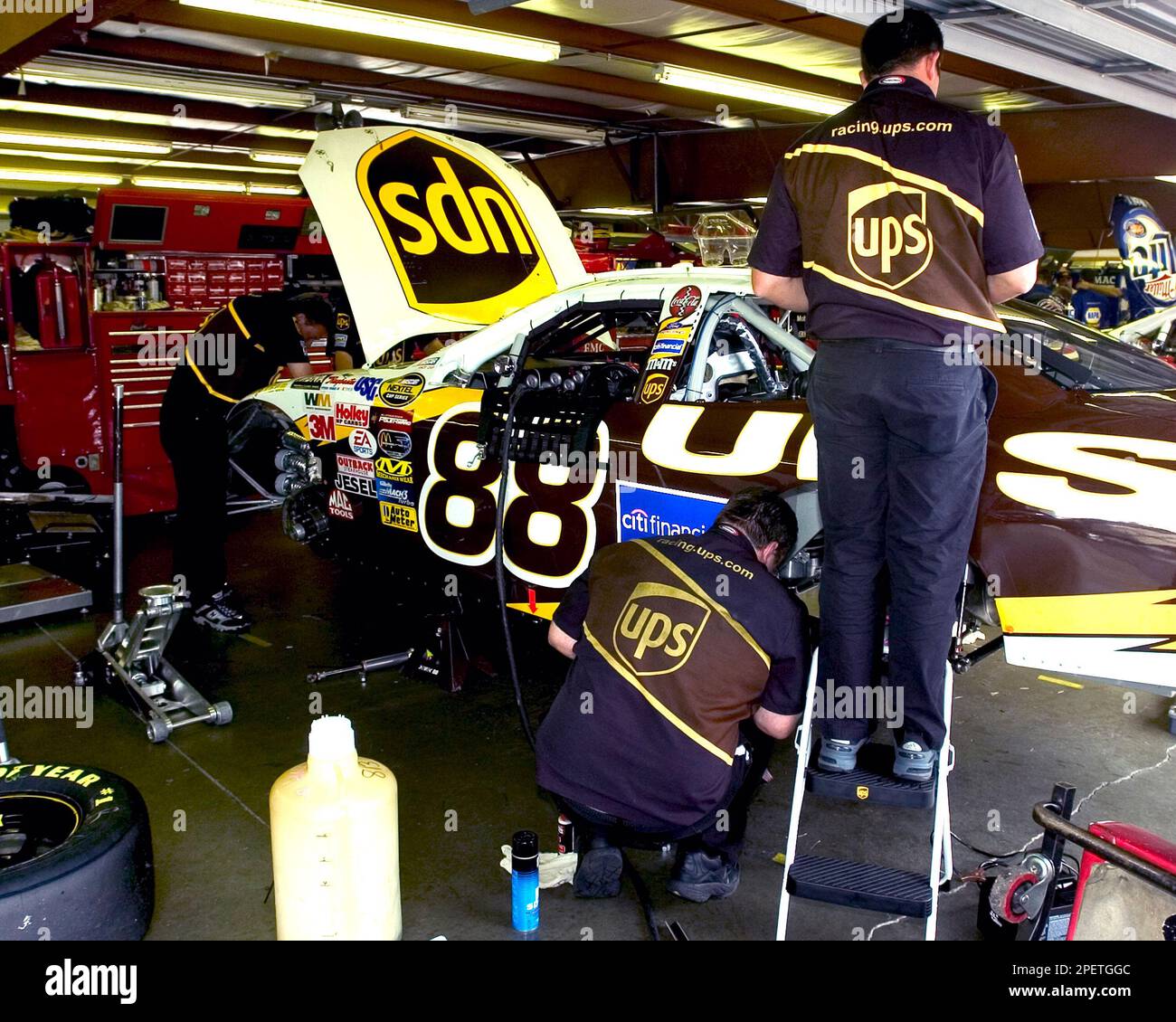 Crew members of the NASCAR Nextel Cup UPS team work on their car during ...