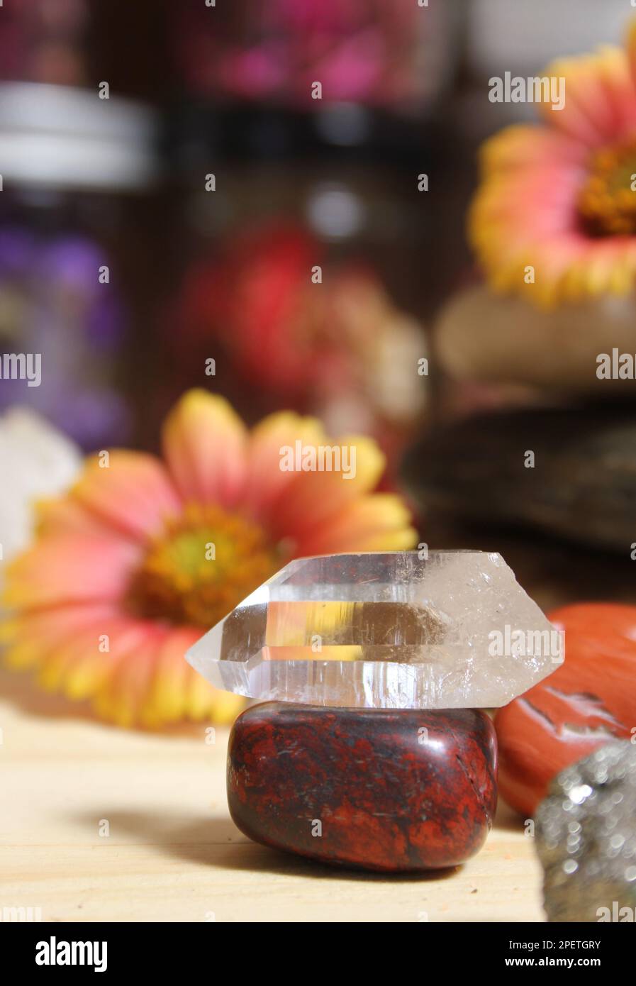 Quartz Crystal Balanced on Bloodstone With Flowers in Background Stock ...