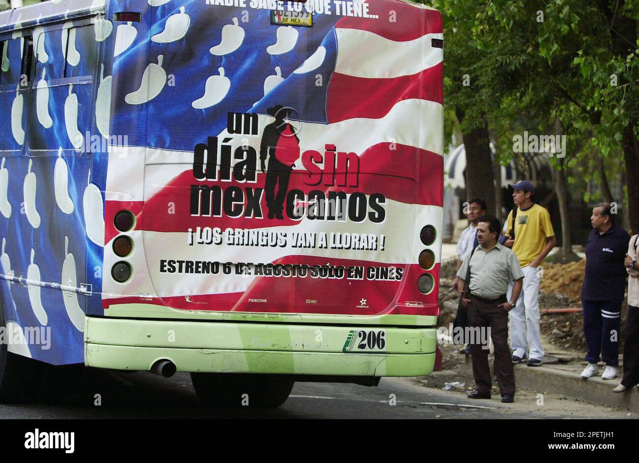 Pedestrians wait to cross the street as a bus passes with the ...