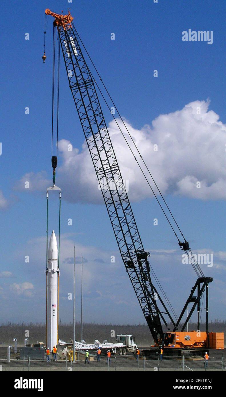 Workers lower a ground-based missile interceptor into its silo at Fort ...