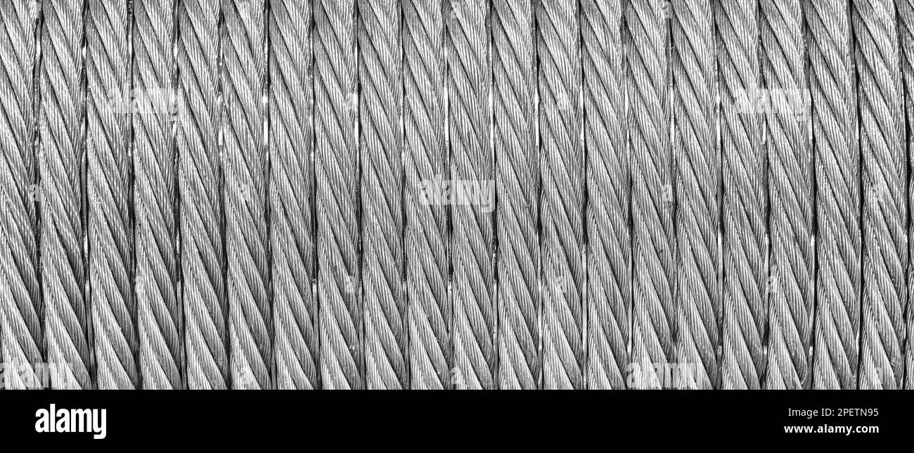 The texture of a new stainless steel cable wrapped in a spool. Abstract ...