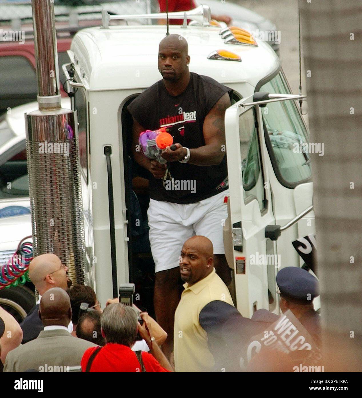 Shaquille O'Neal holds a water gun as he steps from an 18-wheel truck ...