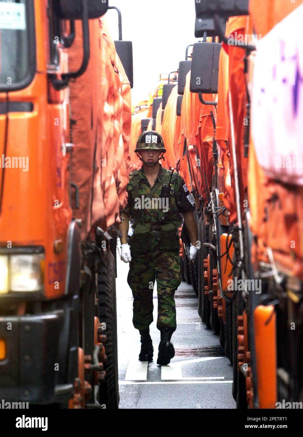 A South Korean Army soldier walks to check trucks carrying rice near ...