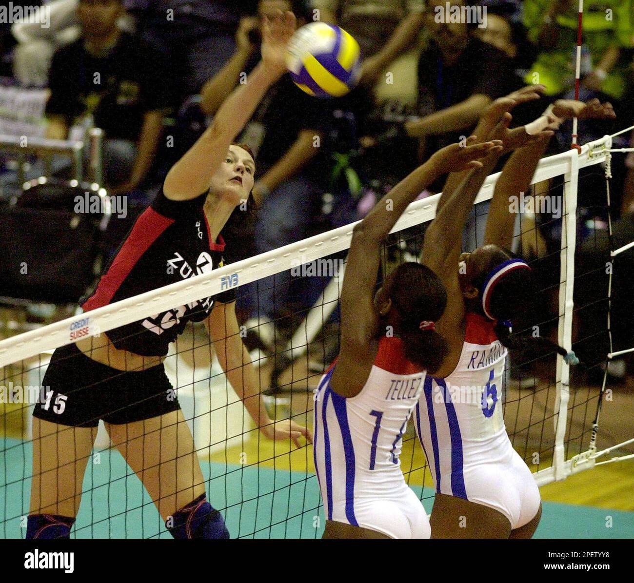 Germany's Angelina Grun, left, spikes toward Cuba's Maria Tellez ...
