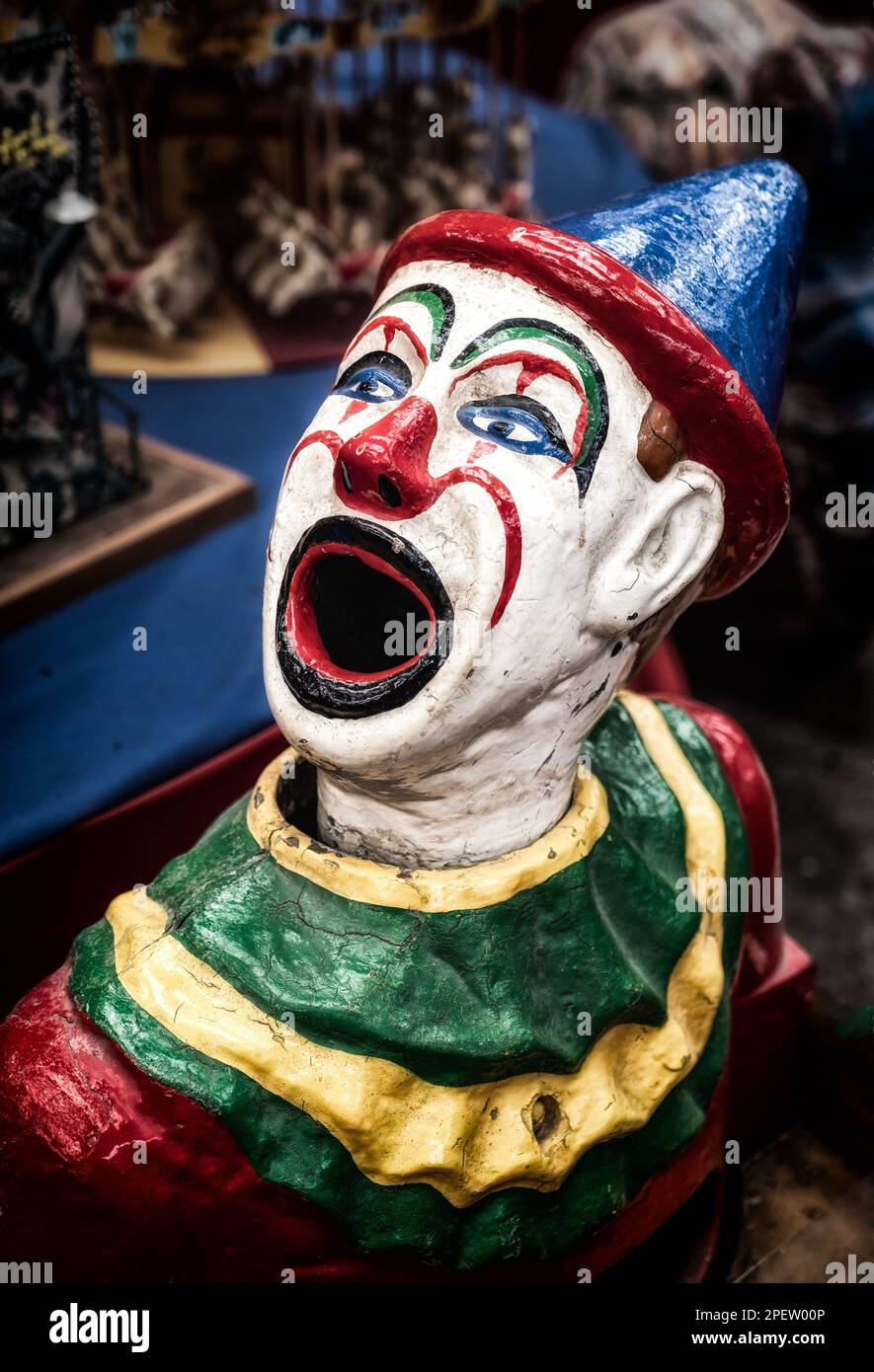 A colorful ceramic clown figurine with wide open mouth and vibrant ...