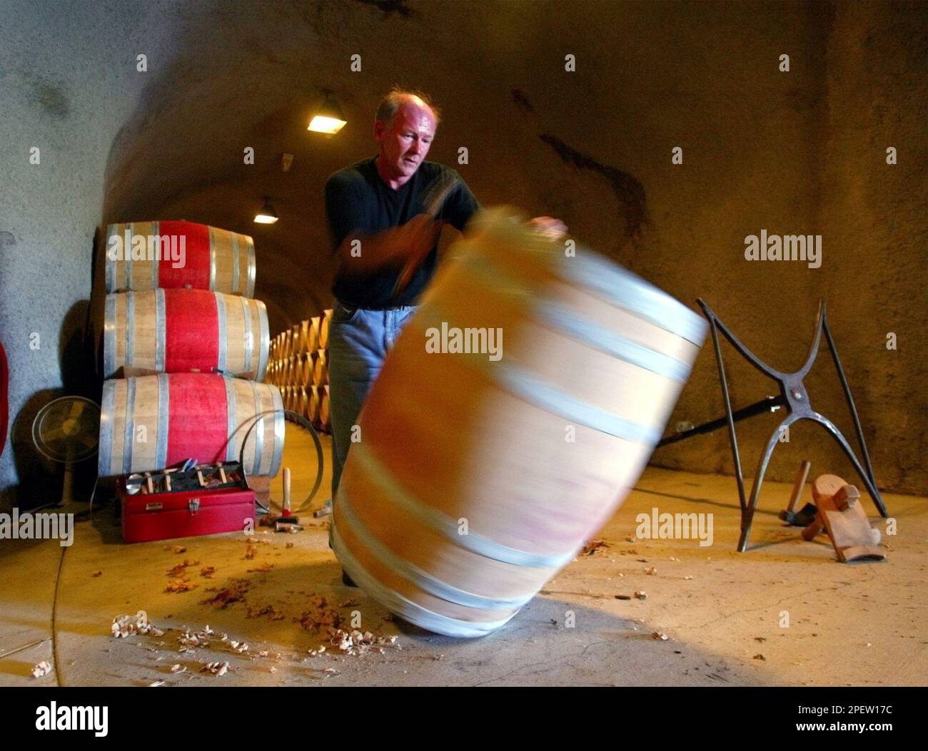 Master cooper Douglas Rennie spins a wine barrel around while hammering ...