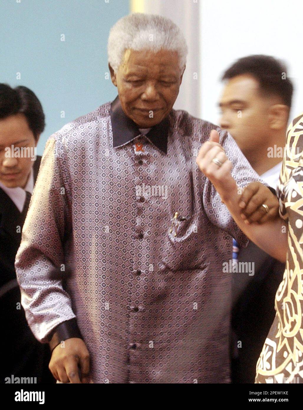 Former South Africa President Nelson Mandela is assisted by an ...