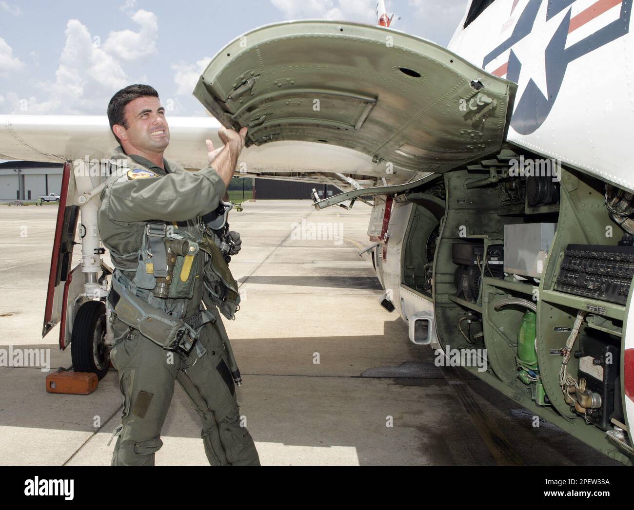 Lt.Cmdr. Rob "Link" Conners closes the side panel on a T-2C at Naval ...