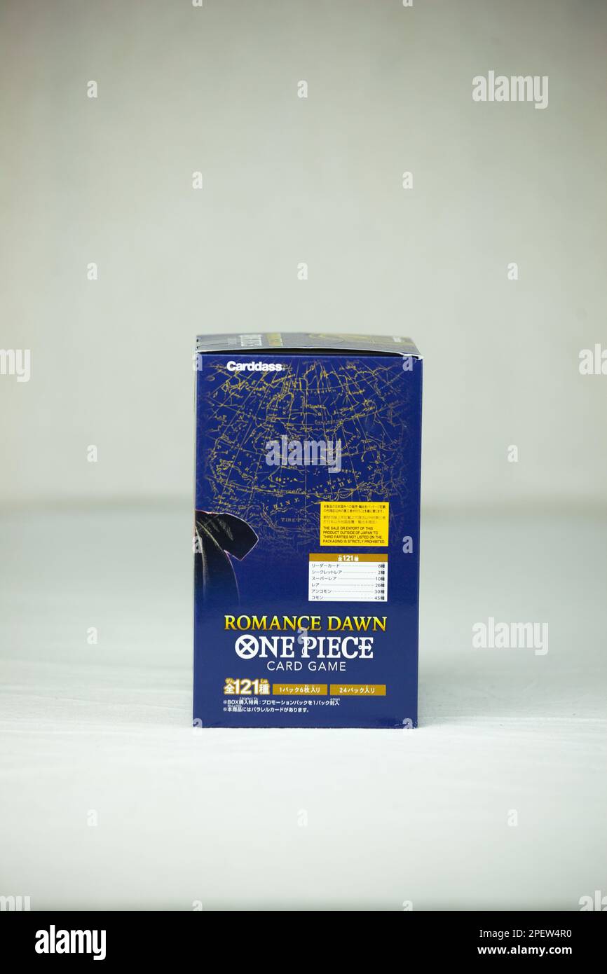 A vertical shot of a Pokemon one piece card game box against a grey ...