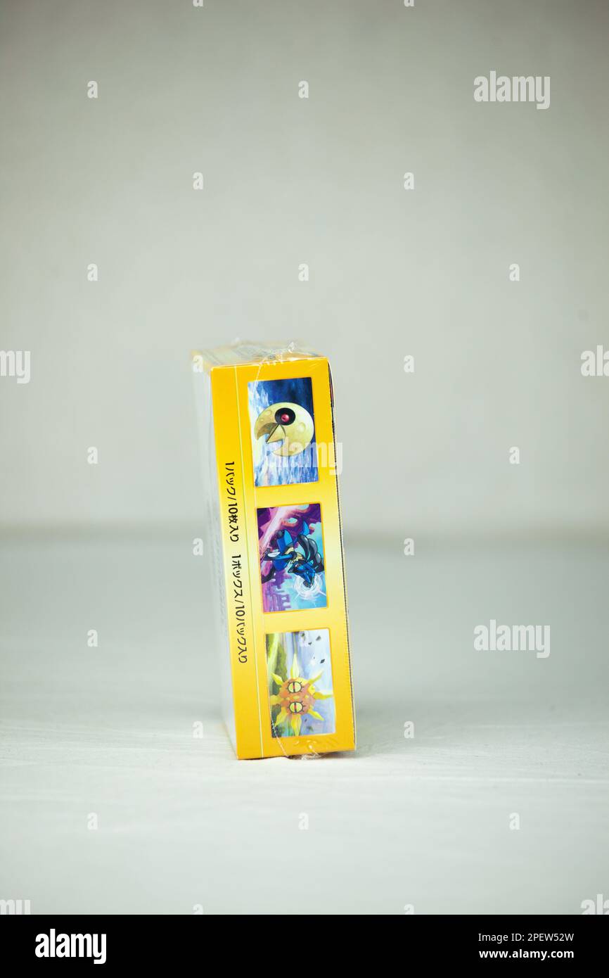A vertical shot of a Pokemon one piece card game box against a grey ...