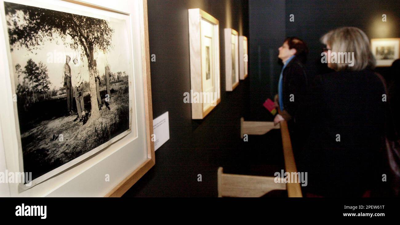 ** FILE ** Visitors look at an exhibit of lynching photographs on ...