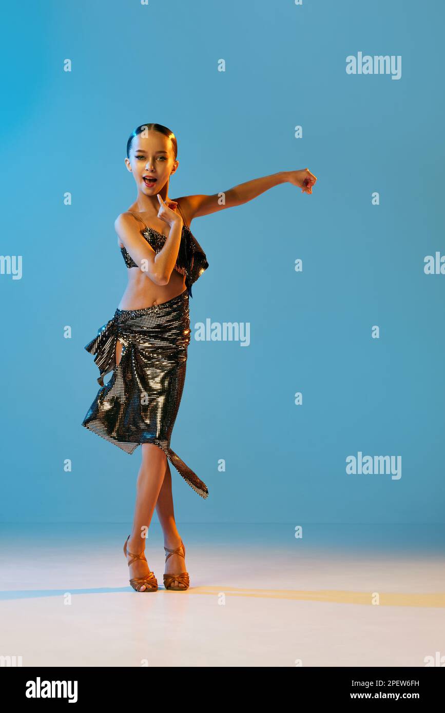 Expressive dance. Beautiful little girl in stage attire dancing latino ...