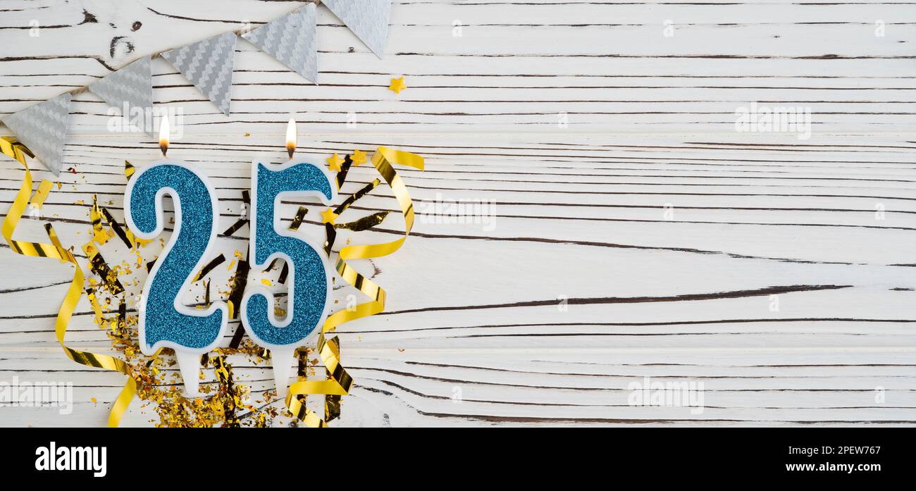 Number 25 blue celebration candle on white wooden background. Happy ...