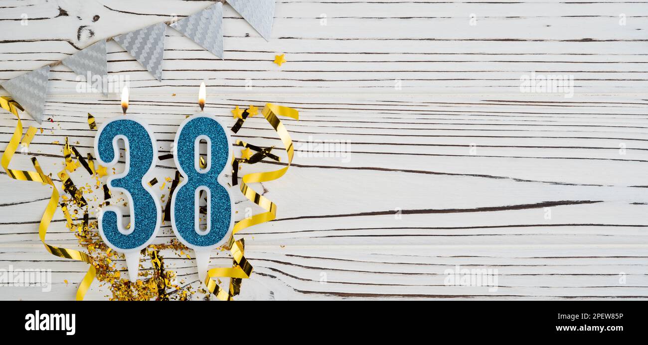 Number 38 blue celebration candle on white wooden background. Happy ...