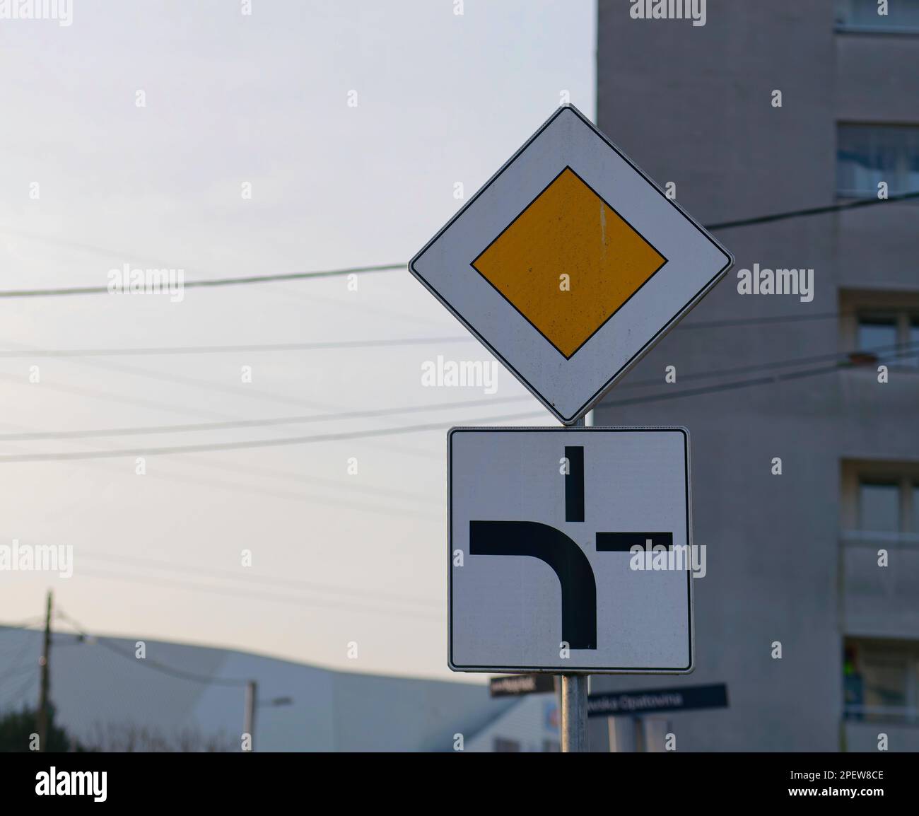 Two street signs securely attached to metal pole against a backdrop of ...