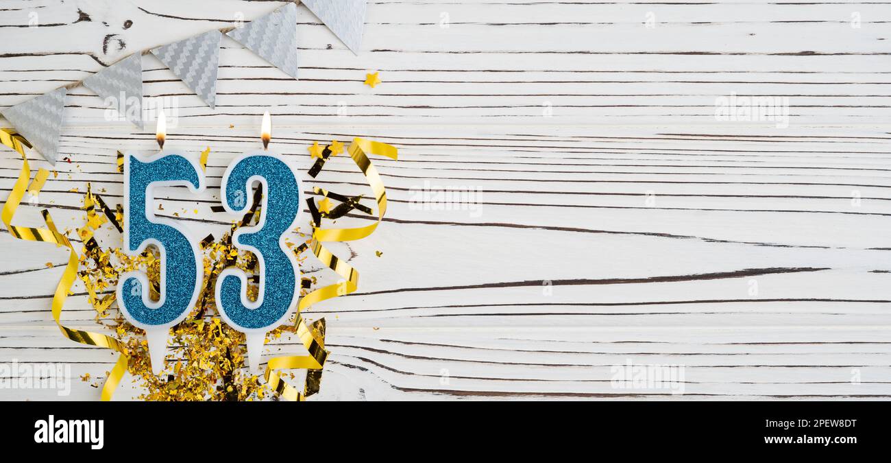 Number 53 blue celebration candle on white wooden background. Happy ...