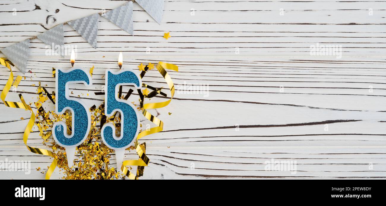 Number 55 blue celebration candle on white wooden background. Happy ...