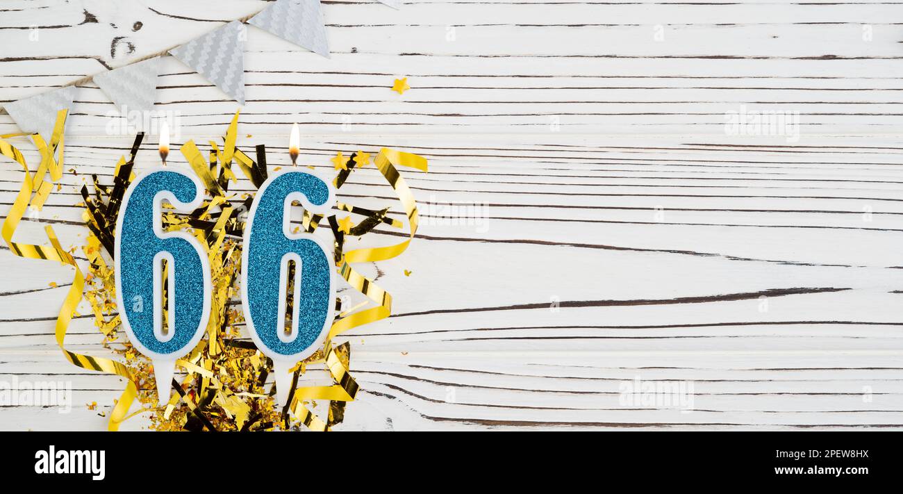 Number 66 blue celebration candle on white wooden background. Happy ...