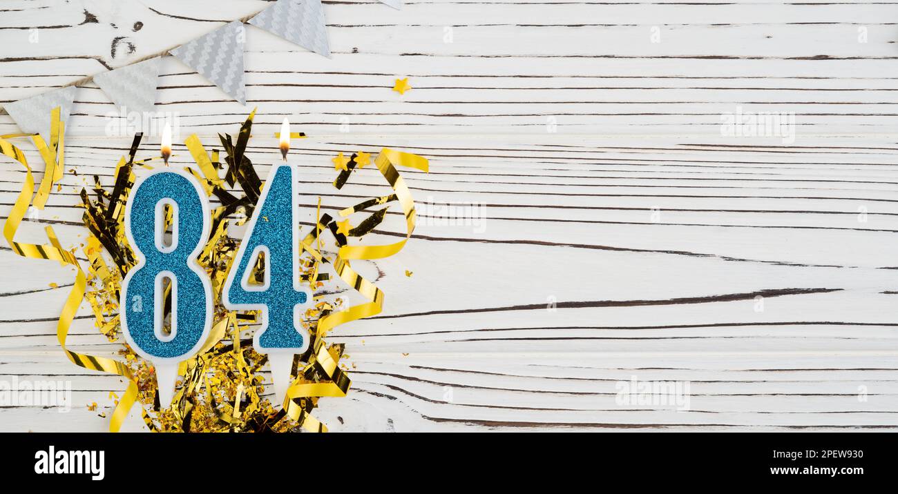 Number 84 blue celebration candle on white wooden background. Happy ...